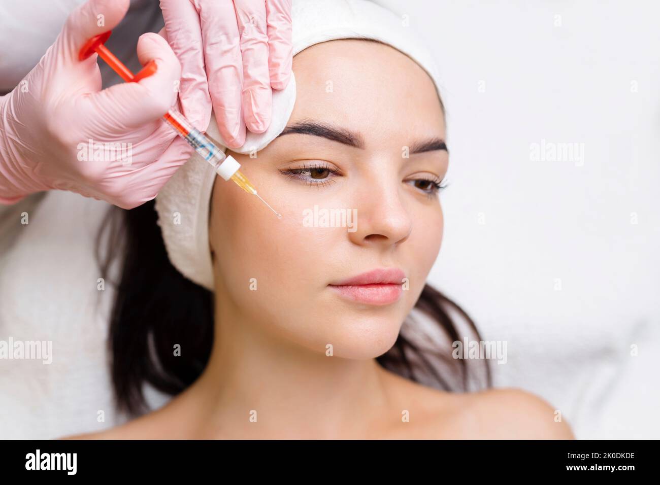 Cosmetologist makes rejuvenating anti wrinkle injections on the face of ...