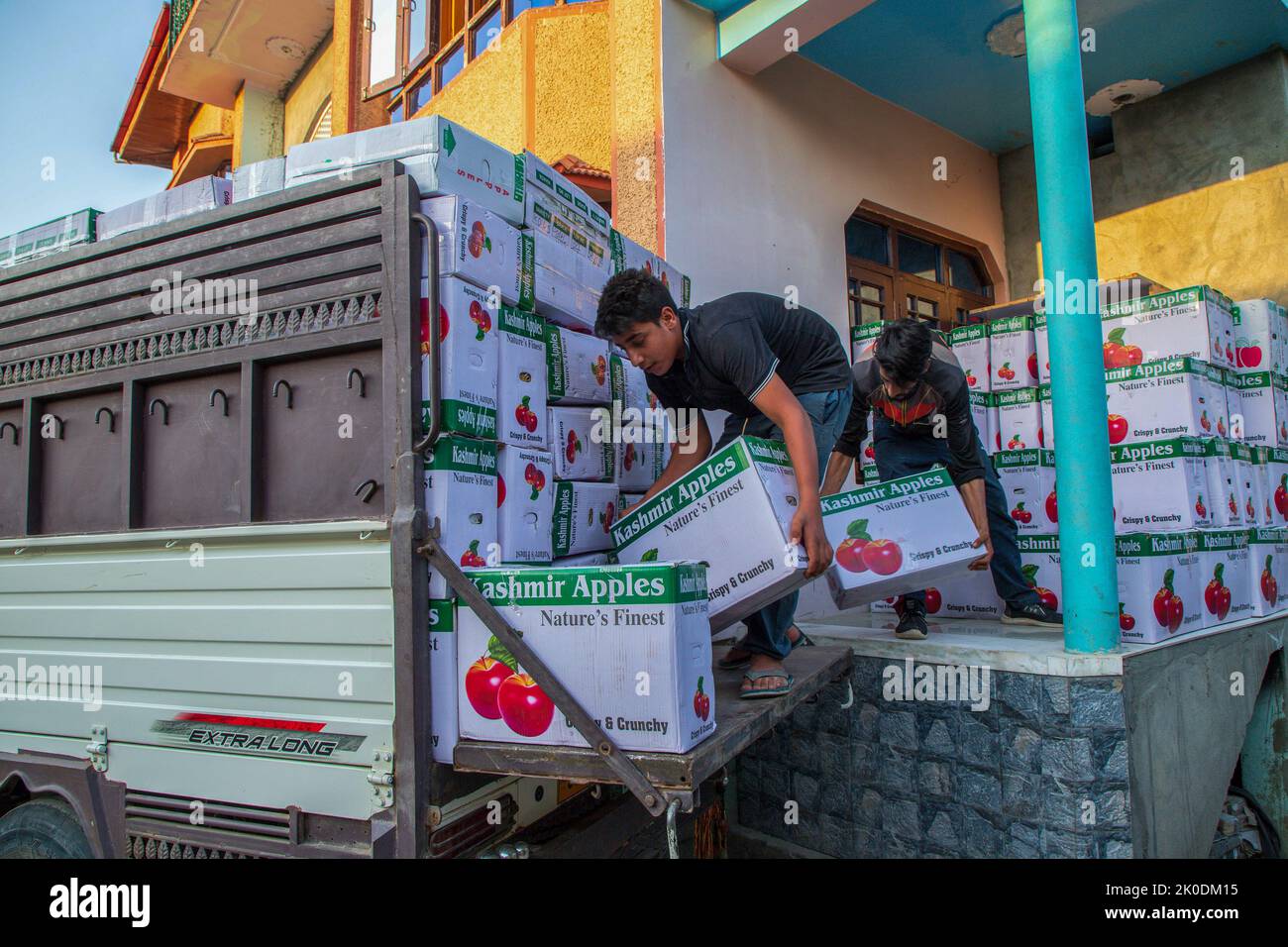 Farmers seen loading fresh boxes of apple on a load carrier during the ...