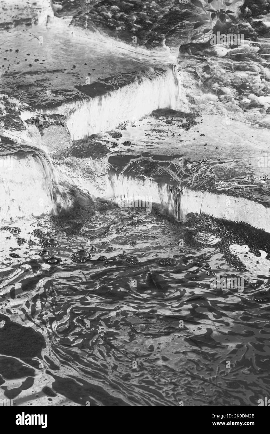 A bubbling creek running over the rocks and stones in a black and white ...