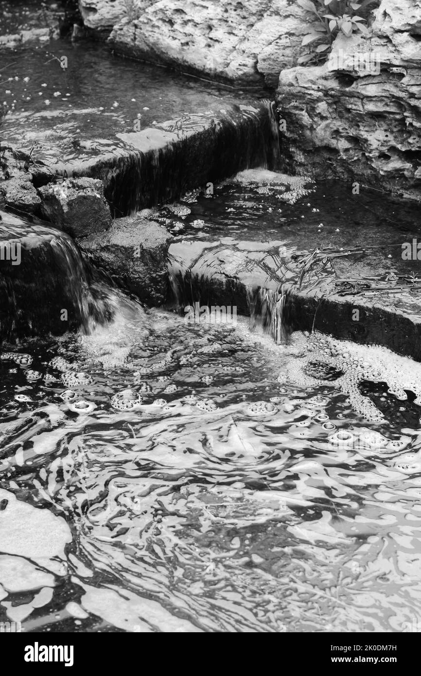 A bubbling creek running over the rocks and stones in a black and white ...