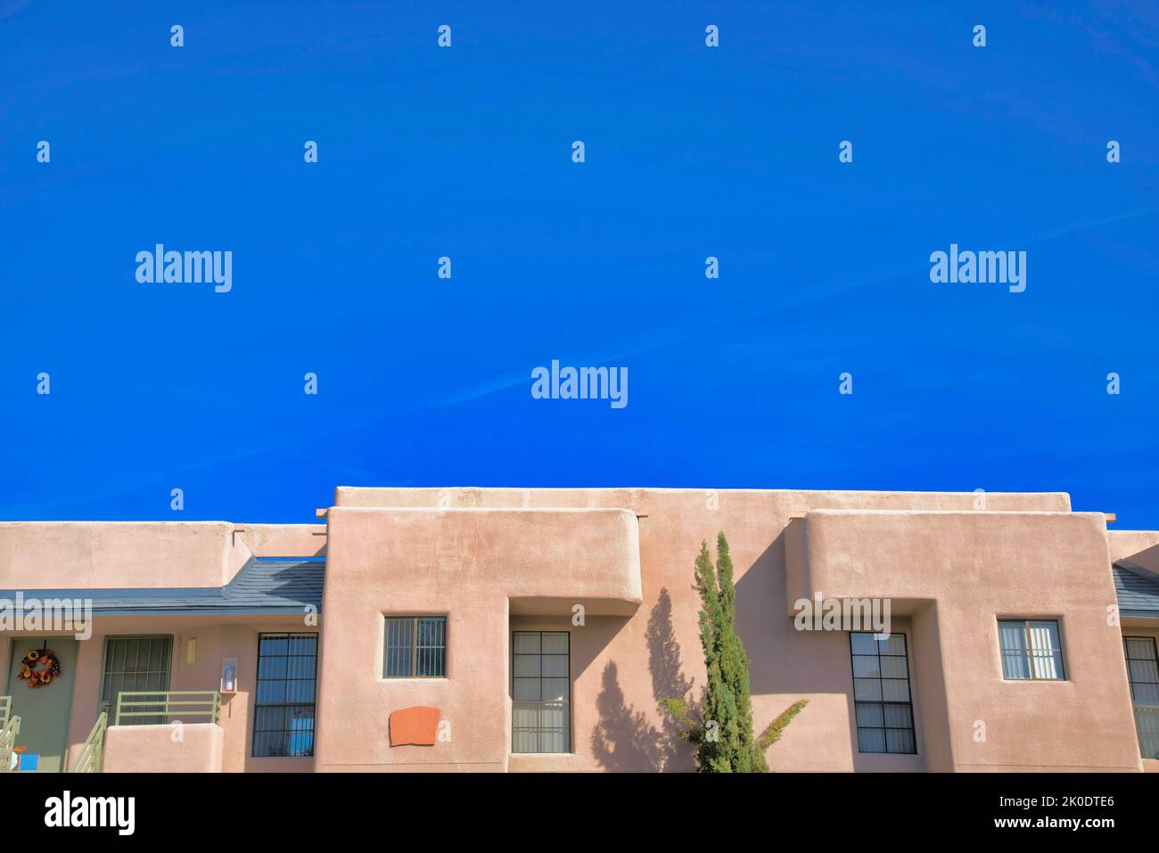 Townhouse with painted cream stucco walls and green front door and ...