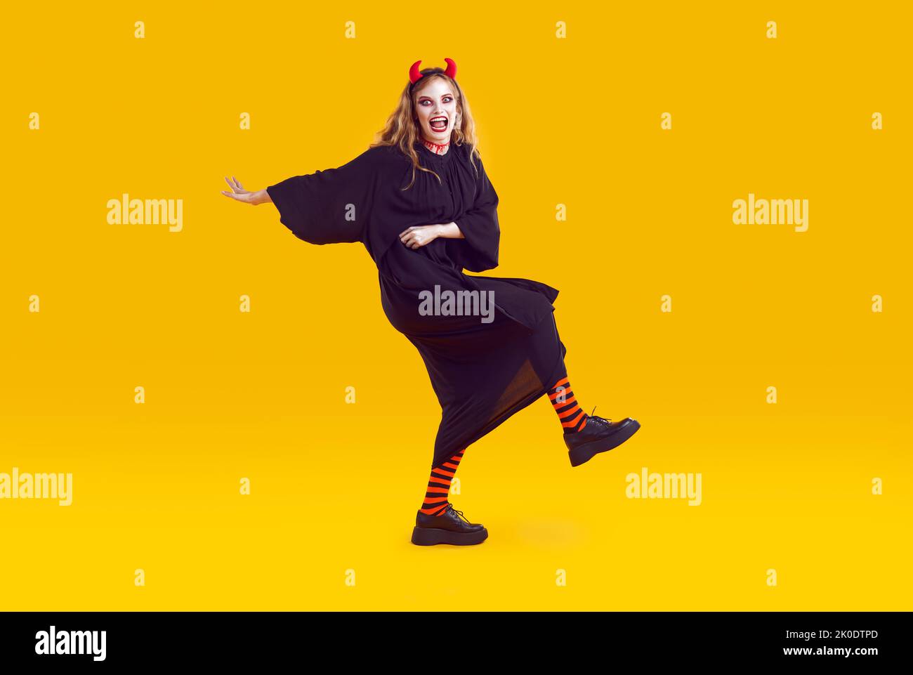 Scary dancing emotional woman with open mouth dressed as crazy devil ...