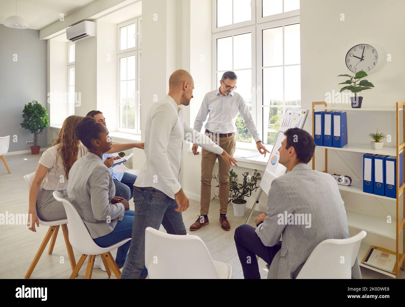 Man business couch teaches explains something to group of adult ...