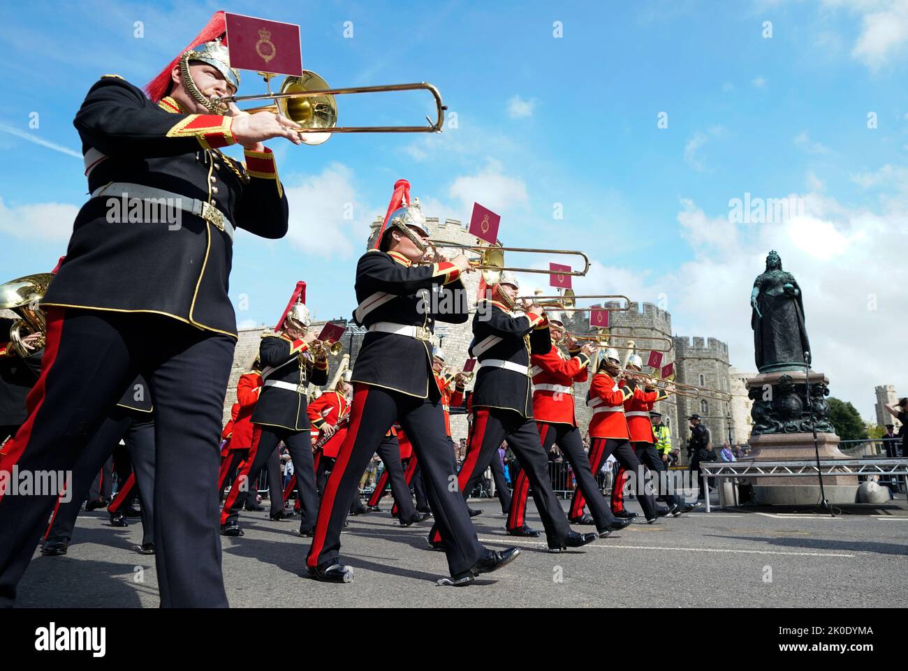 The band of The Household Cavalry march past a statue of Queen Victoria ...