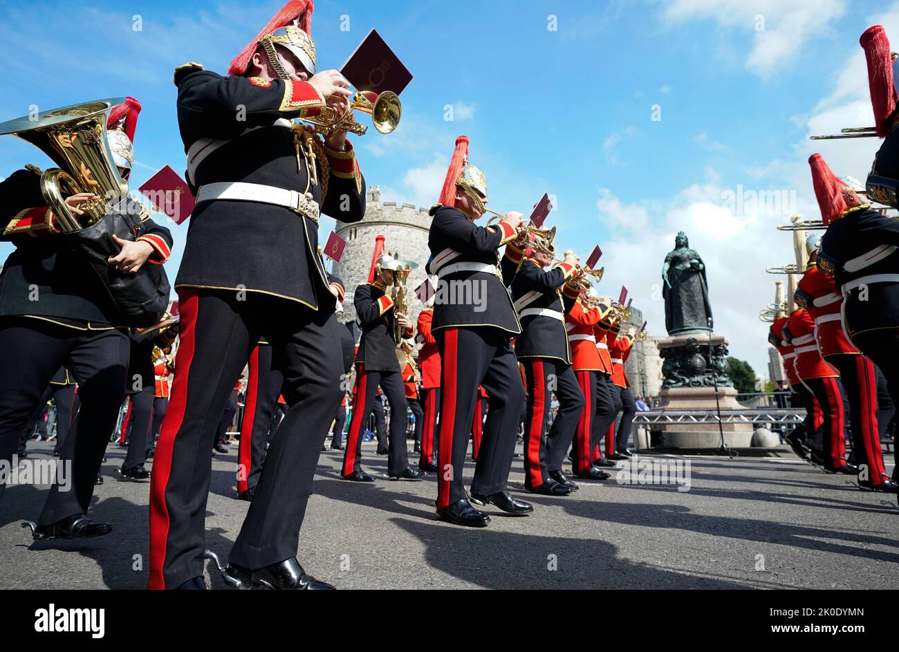The band of The Household Cavalry march past a statue of Queen Victoria ...