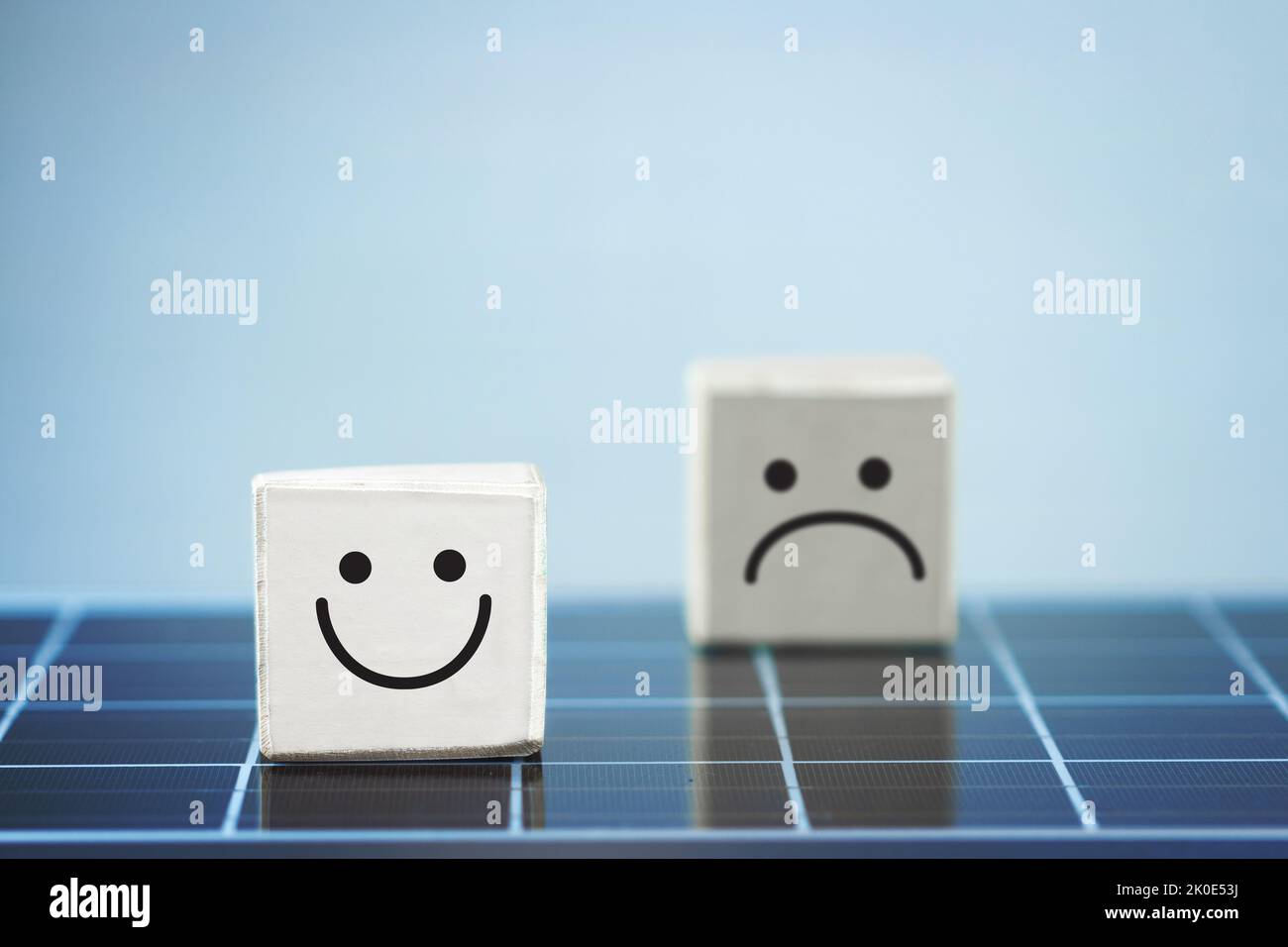 Smile face in bright side and sad face in dark side in wooden block ...