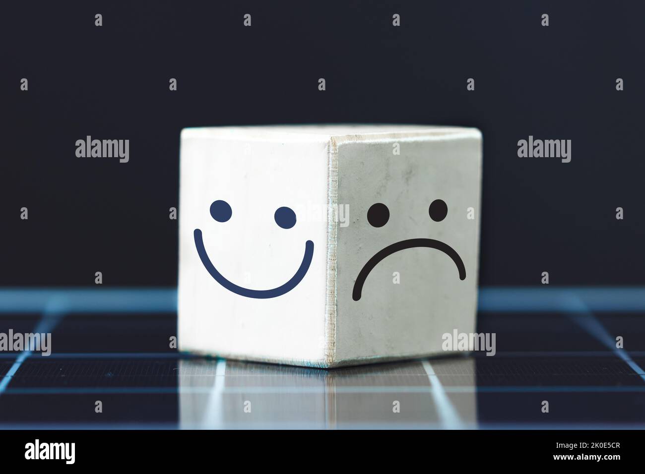 Smile face in bright side and sad face in dark side in wooden block ...