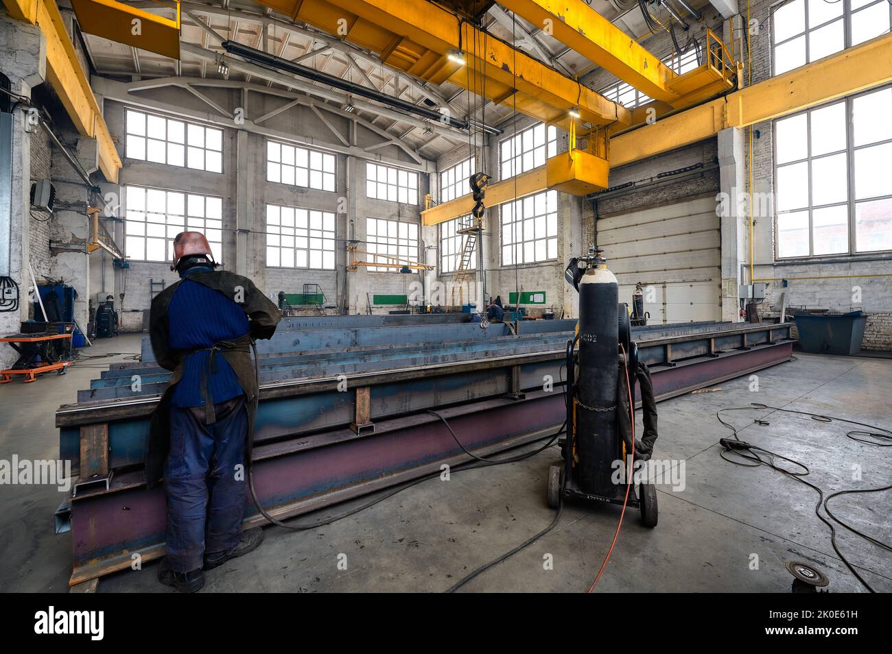 Laborer works with metal details in welding workshop Stock Photo - Alamy