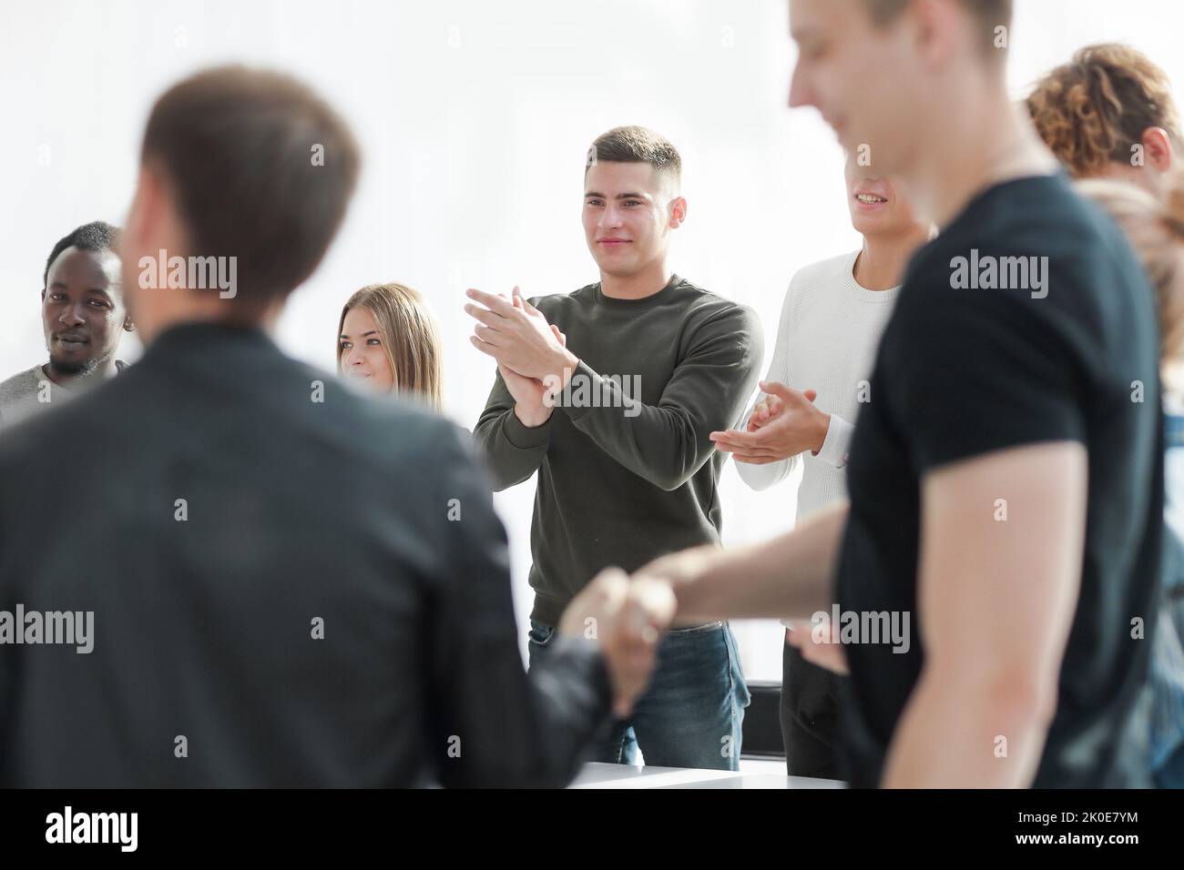 group of diverse young people standing around a round table Stock Photo ...