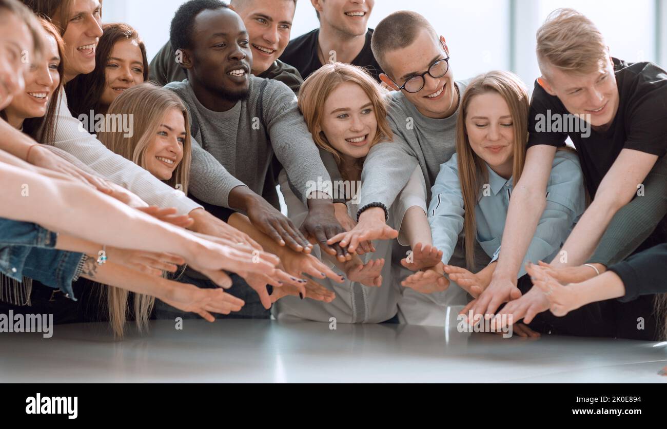 group of smiling young people joining their hands Stock Photo - Alamy
