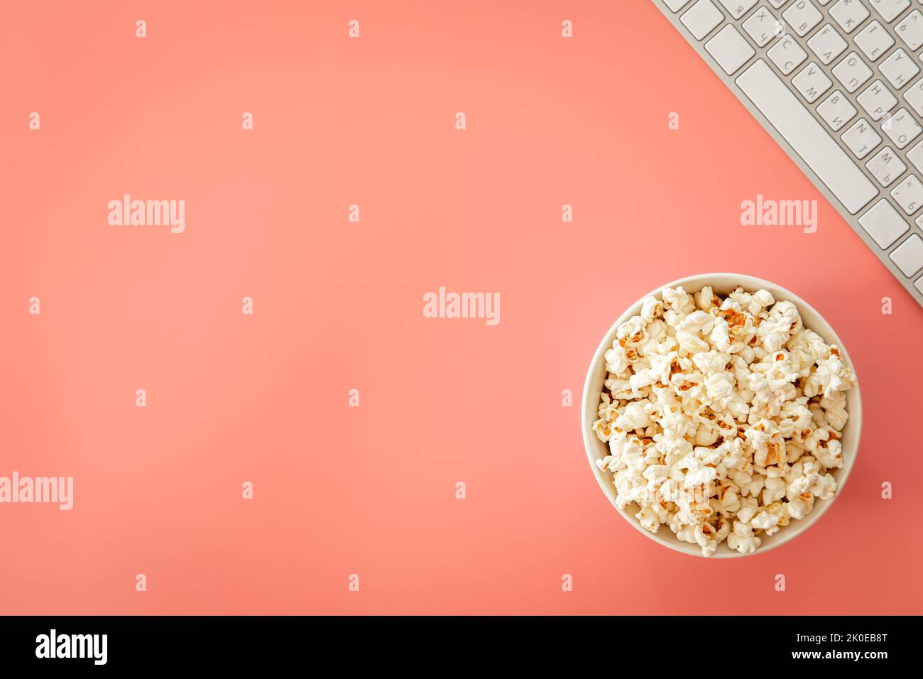 Popcorn and keyboard on pink background, flat lay Stock Photo - Alamy