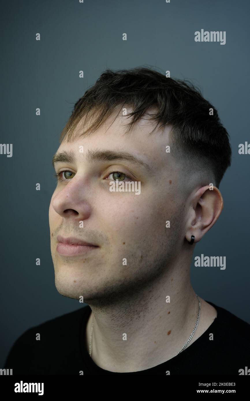Side view of young man isolated on gray background with fresh hairstyle ...