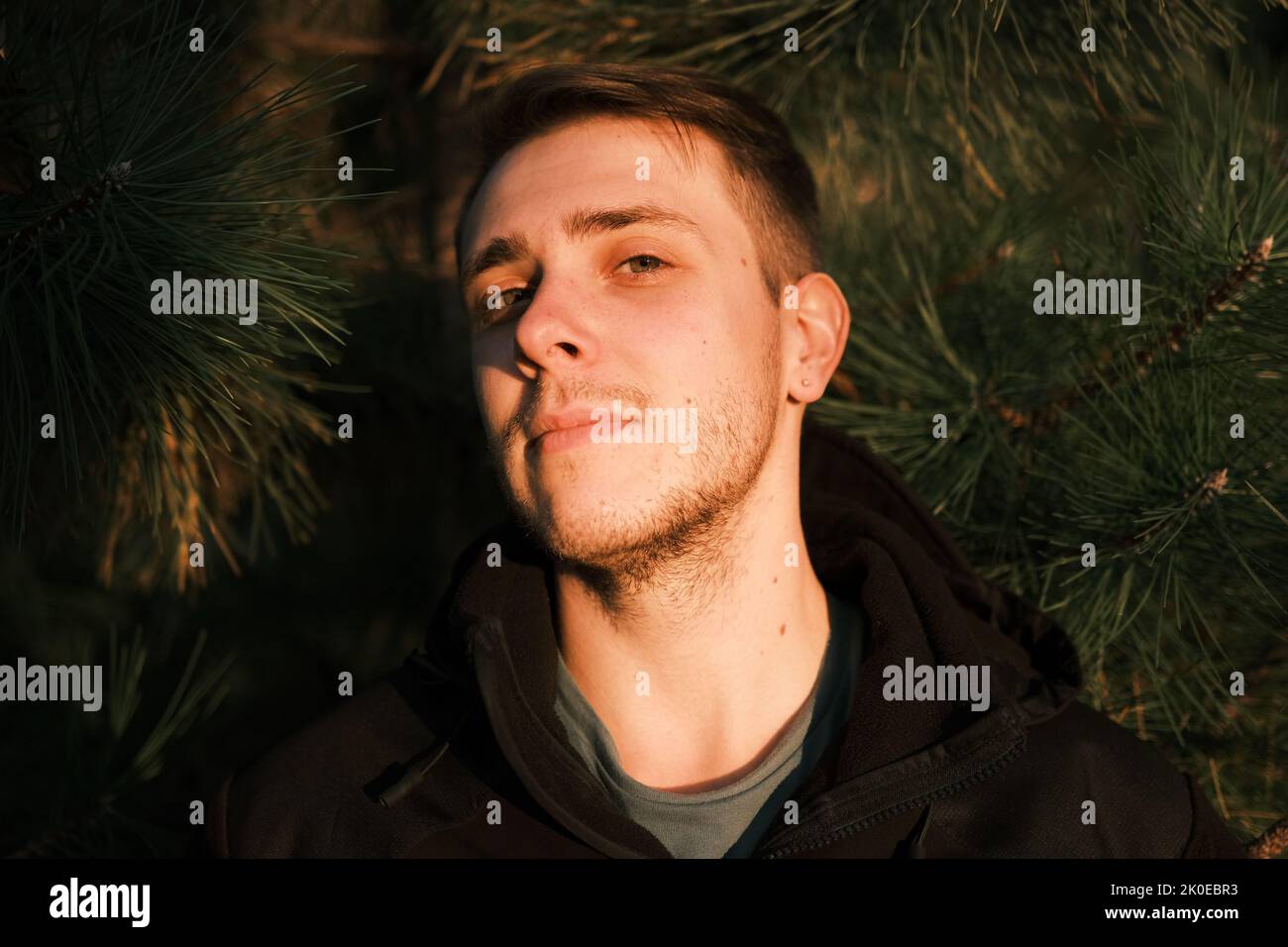 A portrait young man with gray hair walks through a forest and enjoys a ...