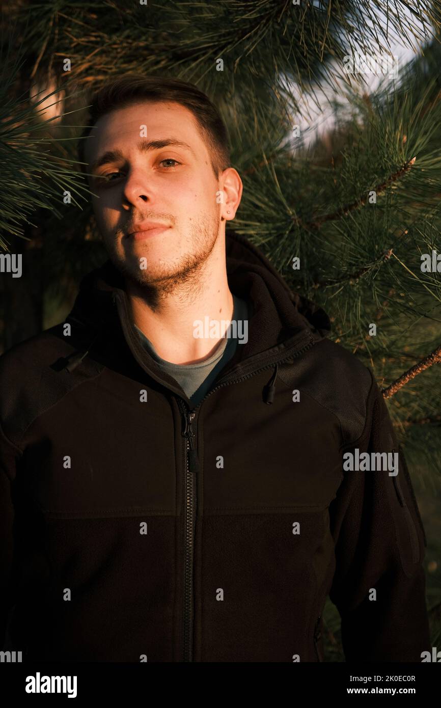 A portrait young man with gray hair walks through a forest and enjoys a ...