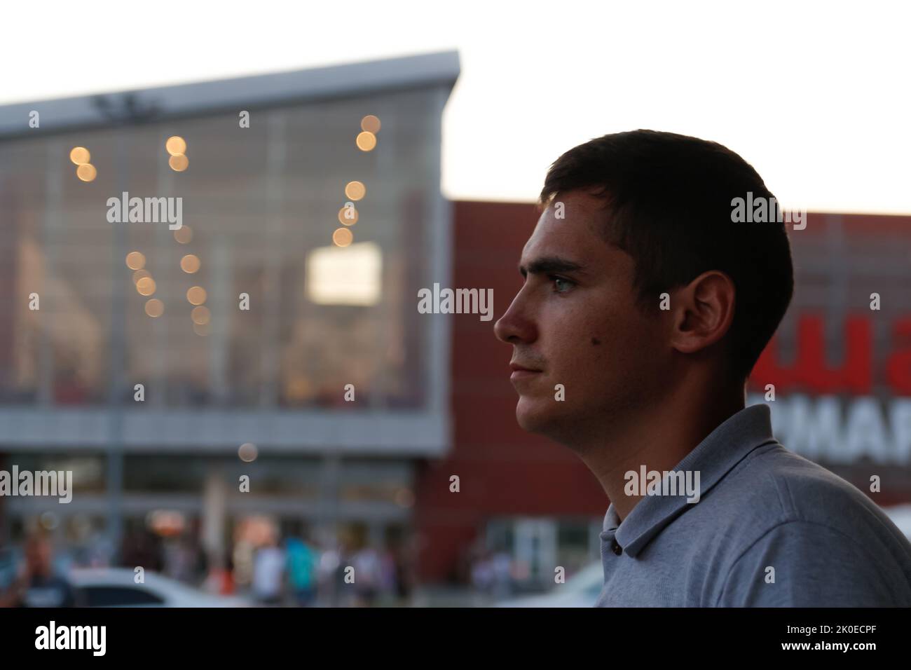 Defocus man face profile. 20s man standing near shopping mall. Night ...