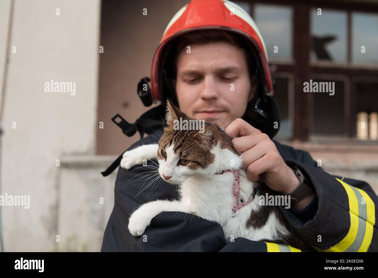 Close-up portrait of heroic fireman in protective suit and red helmet ...