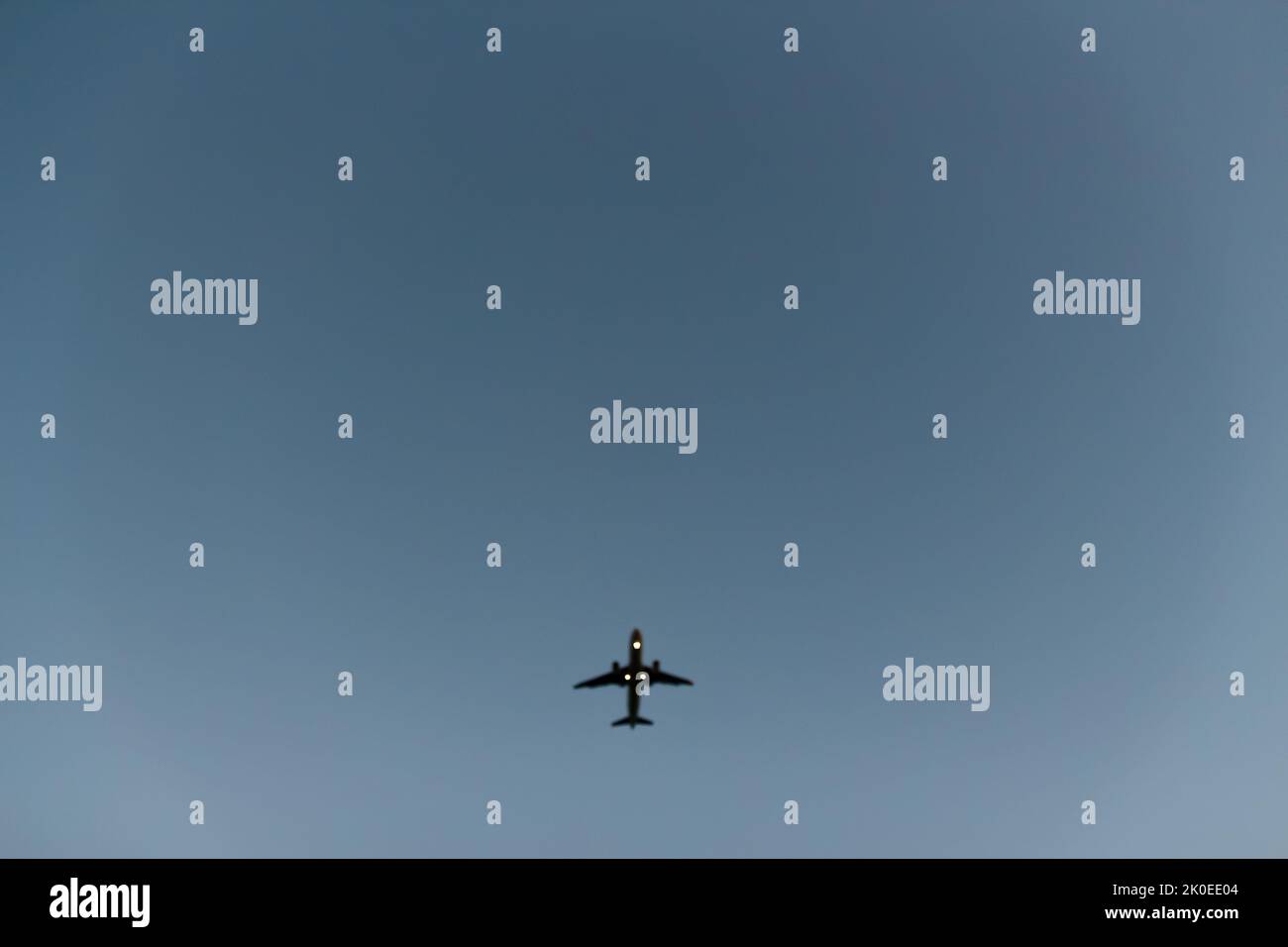 Defocus night plane. Airplane flying across blue sky. Blurred black ...