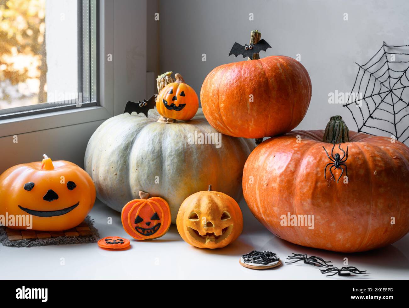 Halloween pumpkins and sweets on white windowsill at home. Vegetables ...