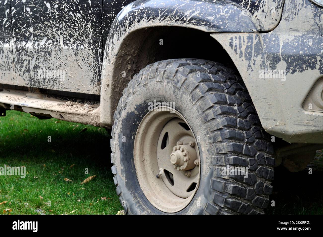 SUV covered in mud. The wheels and body of the car are splattered with ...