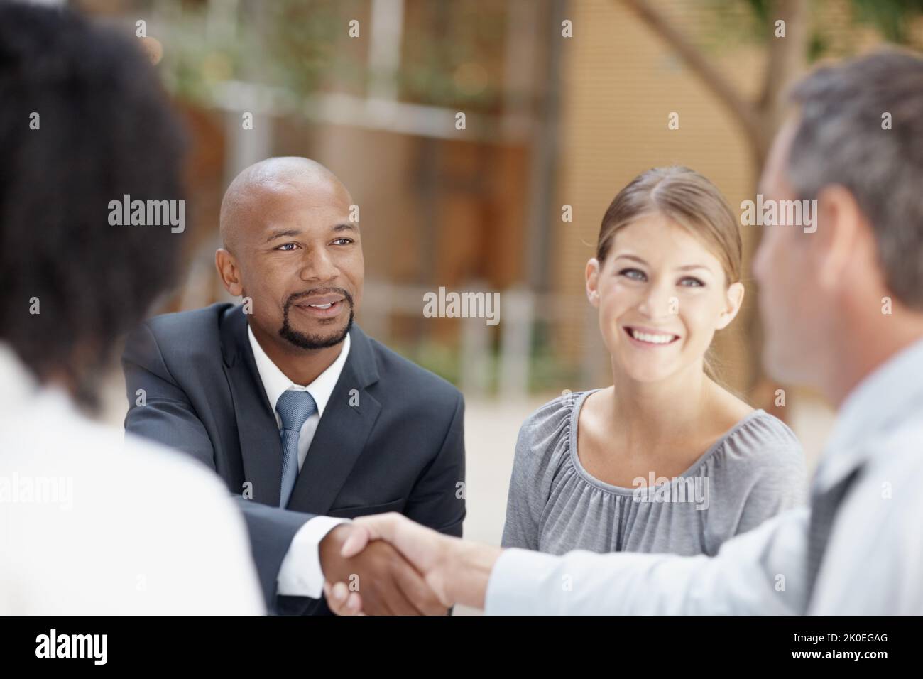 Diverse coworkers shaking hands talking hi-res stock photography and ...