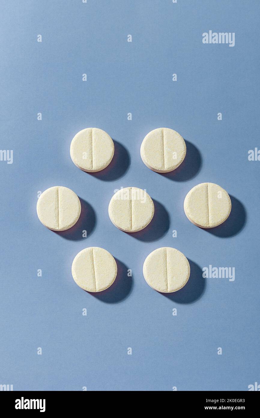 Round tablets with shadows on a blue background Stock Photo - Alamy