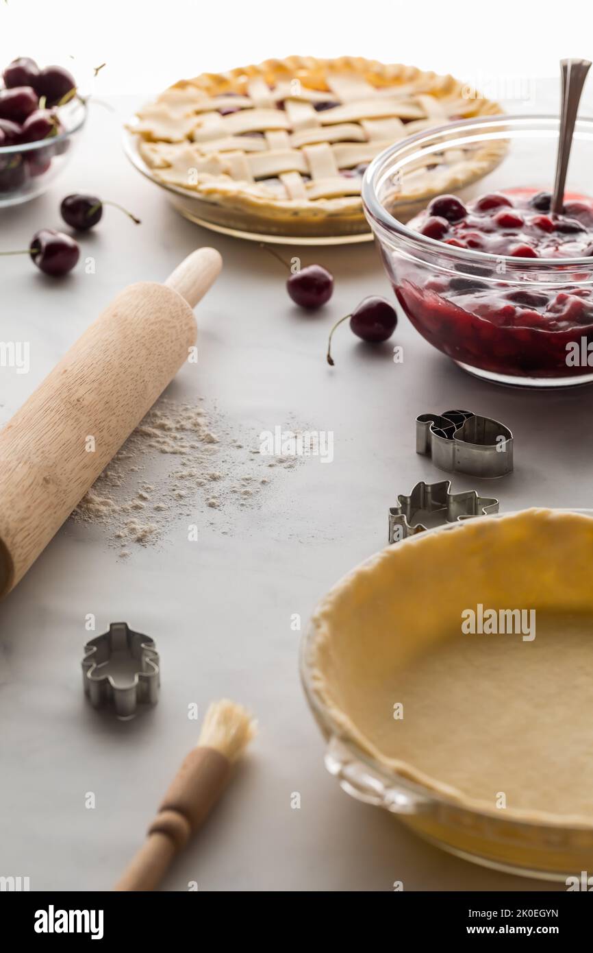 An unbaked pie shell with fresh cherry pie filling in behind Stock ...