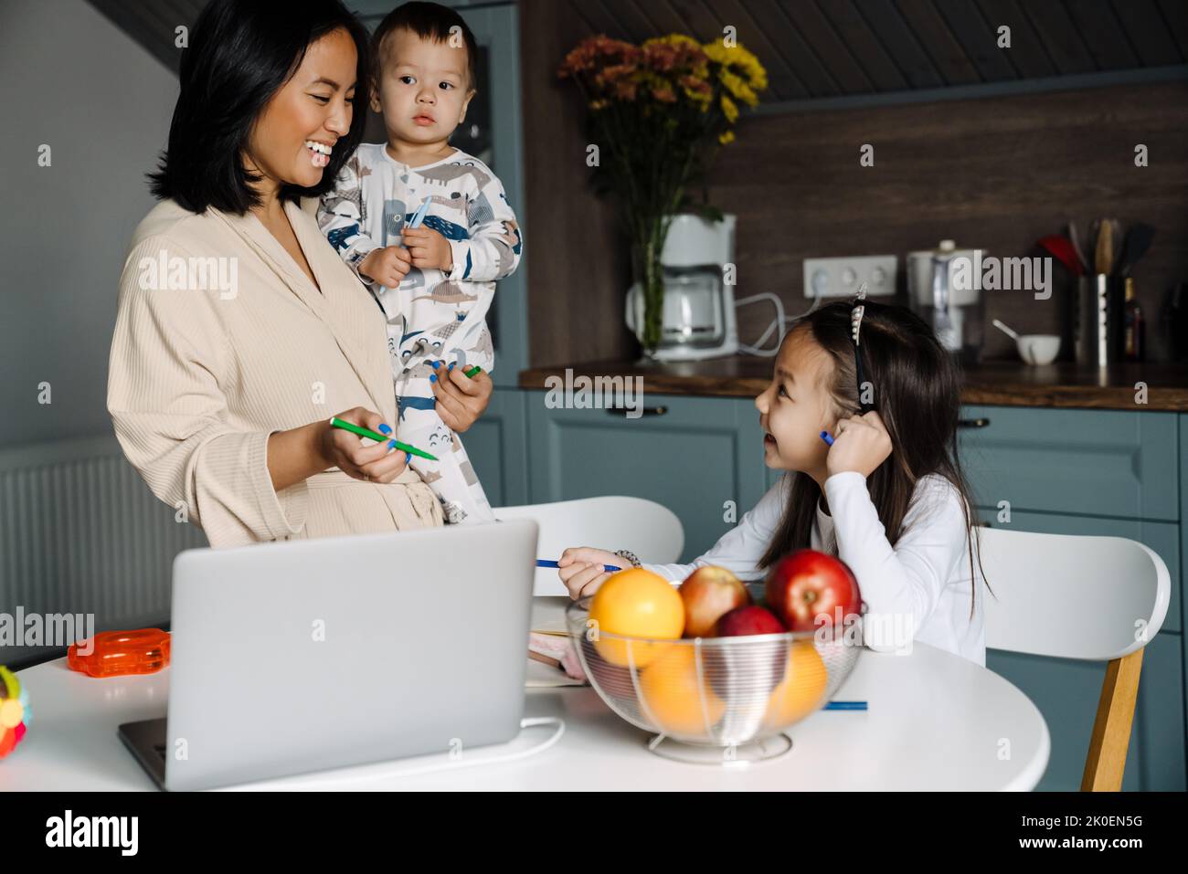 Happy mother laughing while spending time with her children at home ...