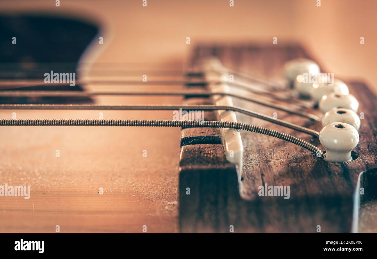 Acoustic guitar bridge and strings close up Stock Photo - Alamy