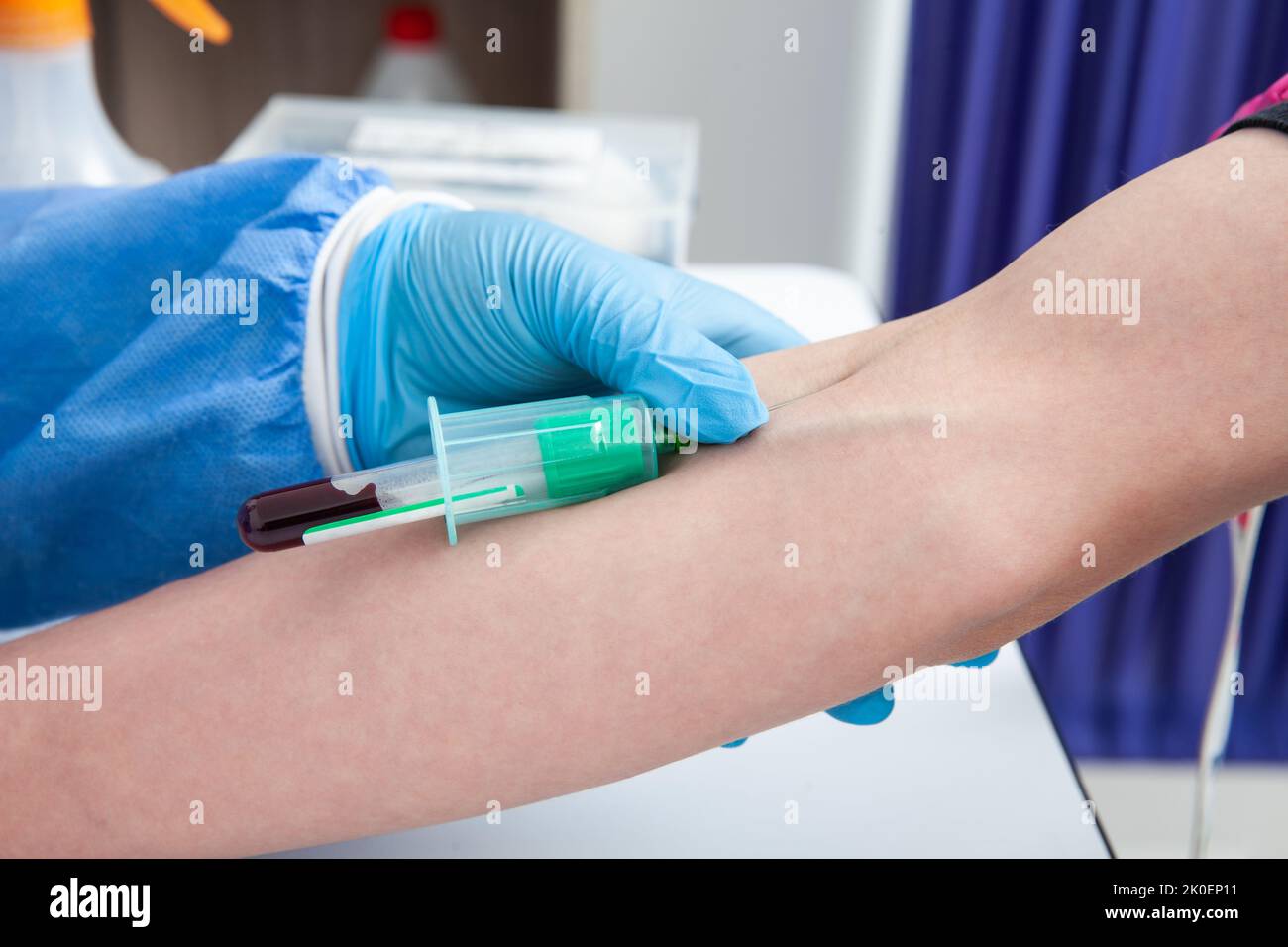 Nurse collecting a blood sample from a male patient in a clinic Stock ...
