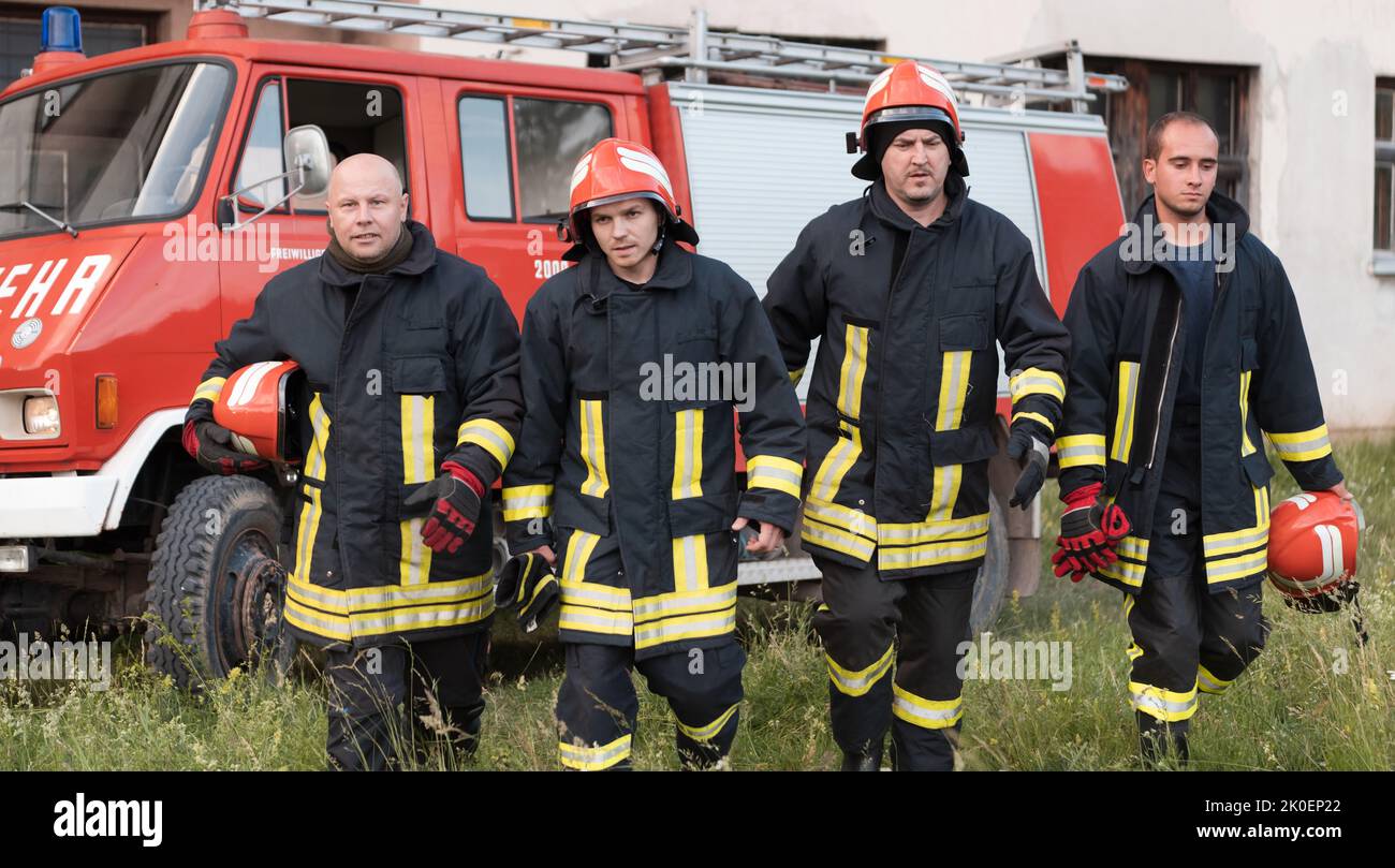 Group of fire fighters standing confident after a well done rescue ...