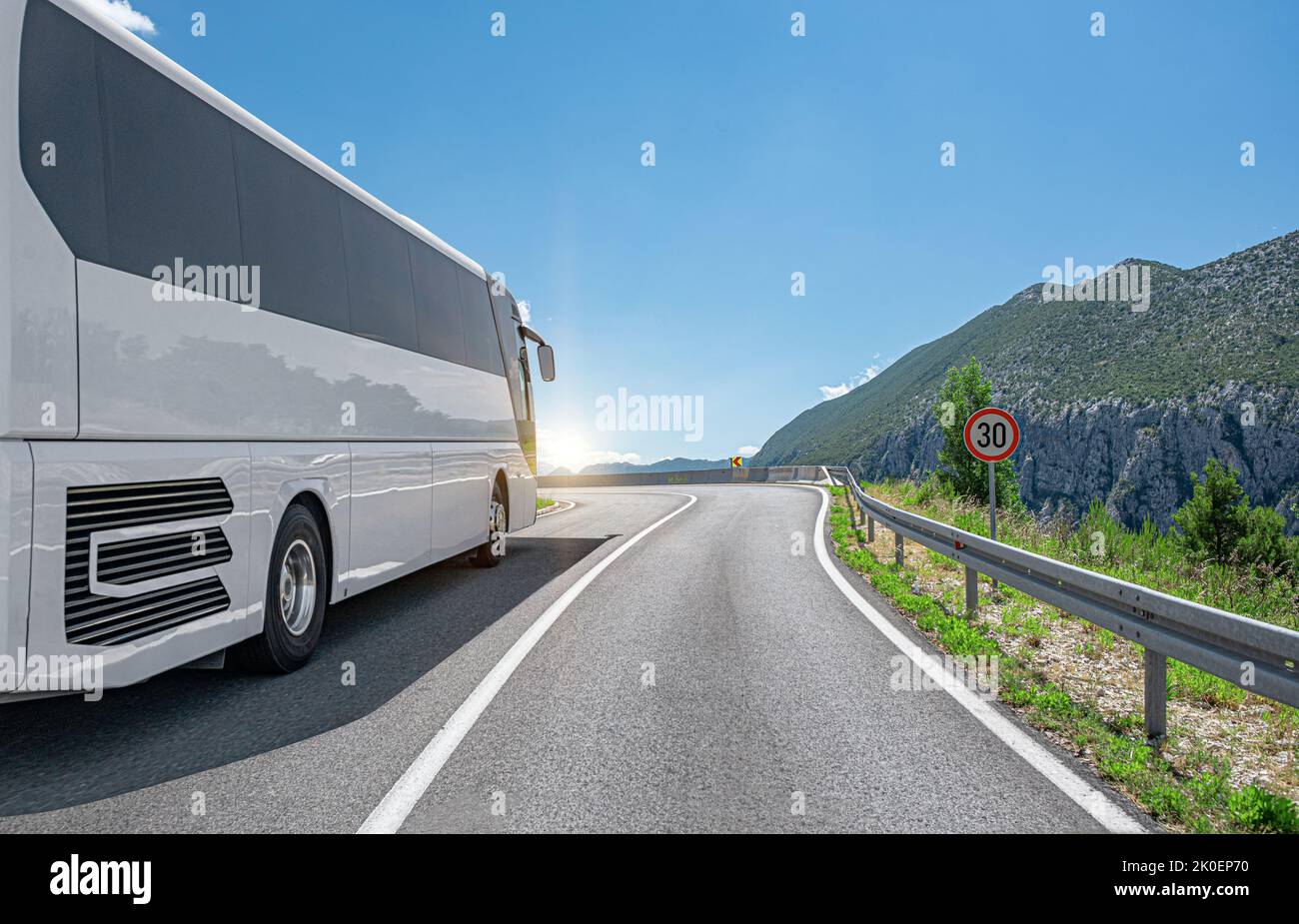 A white bus rides along the highway against the backdrop of a beautiful ...