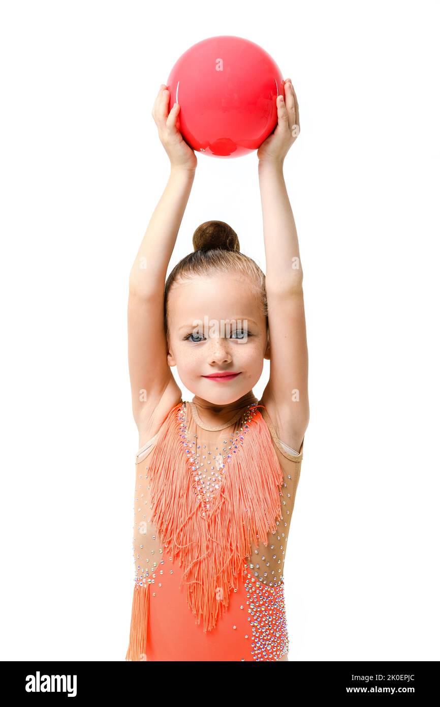 Small gymnastic girl hold rubber ball up on head, studio portrait of ...
