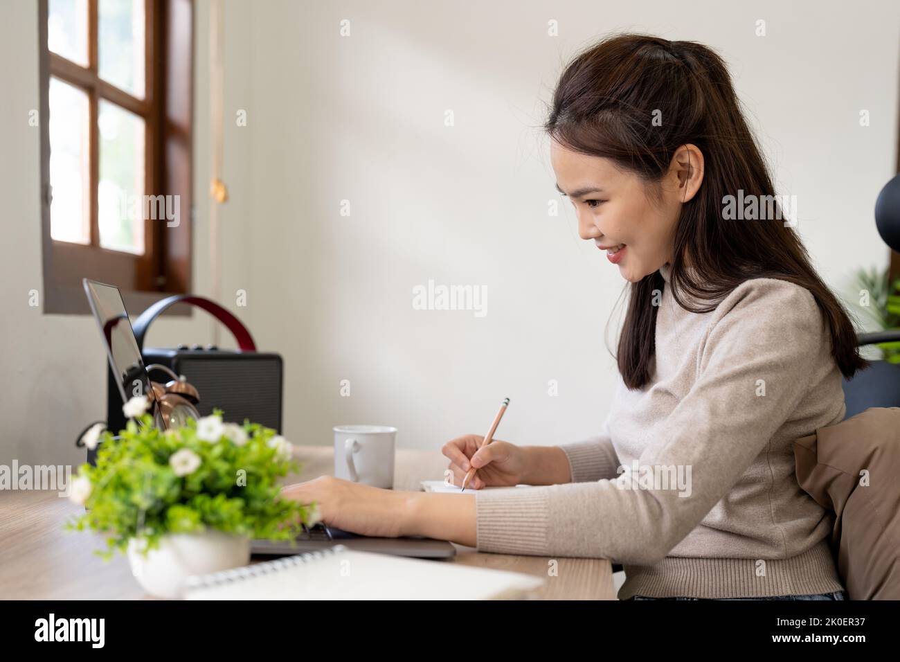 woman wearing using laptop in cafe, writing notes, attractive female ...