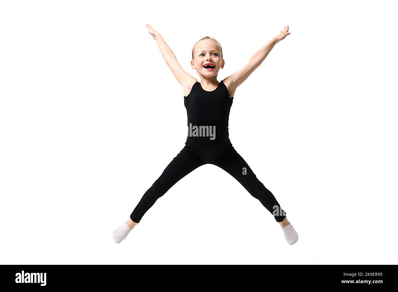 Small gymnast girl jump like star indoors Stock Photo - Alamy