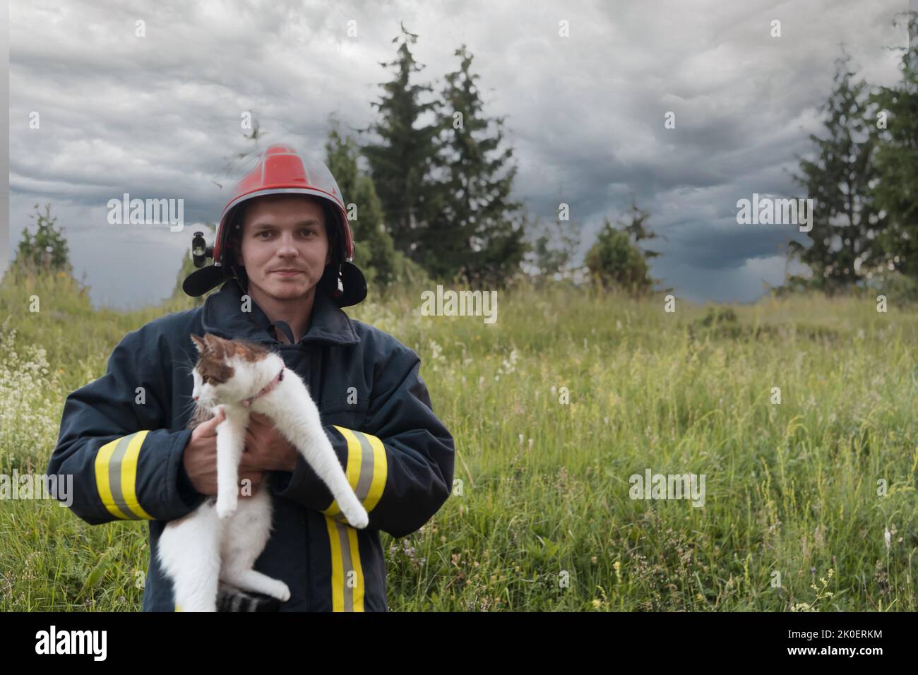 Close-up portrait of heroic fireman in protective suit and red helmet ...