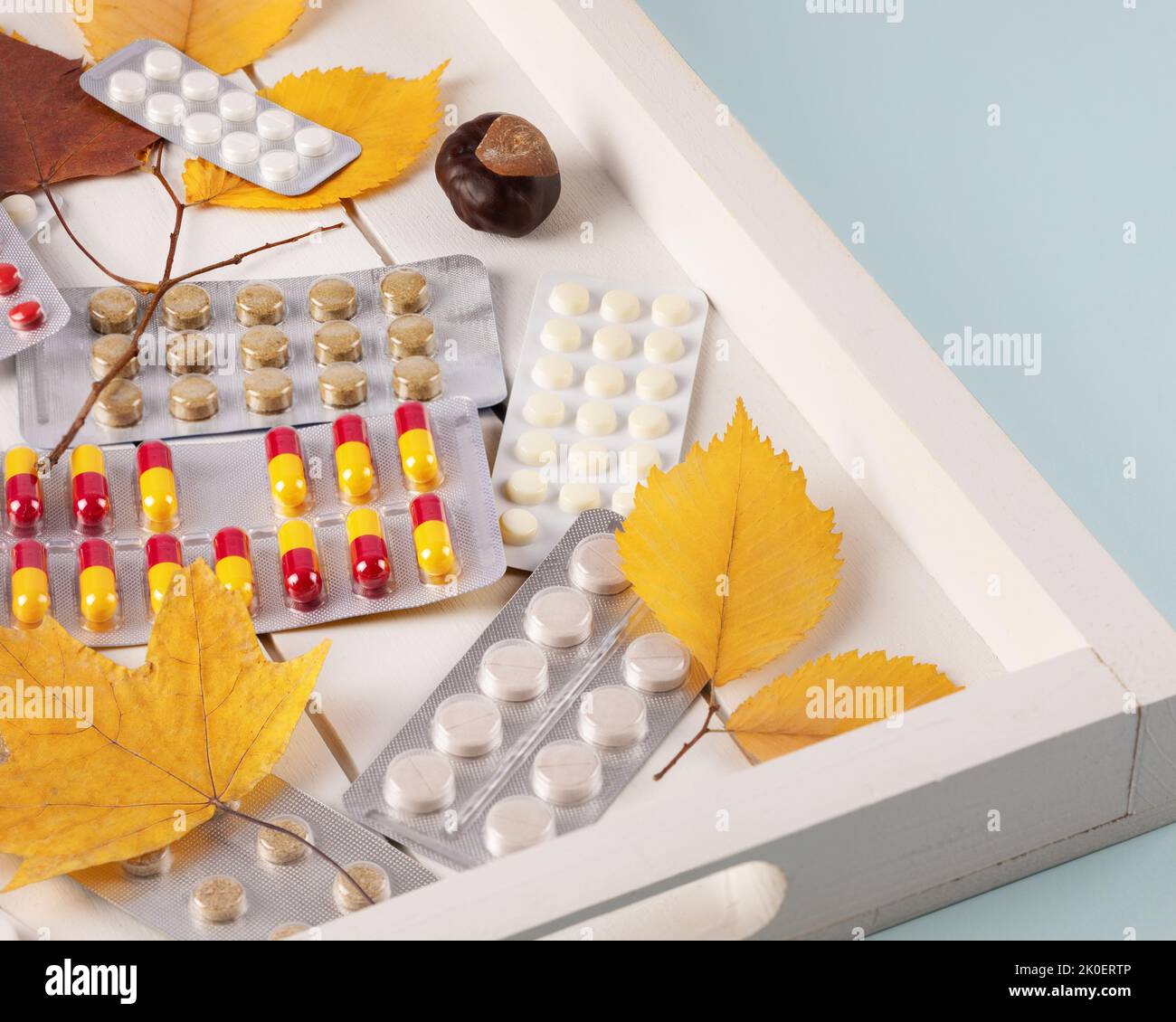 Pharmaceutical card with pills in blister pack with autumn leaves on a ...