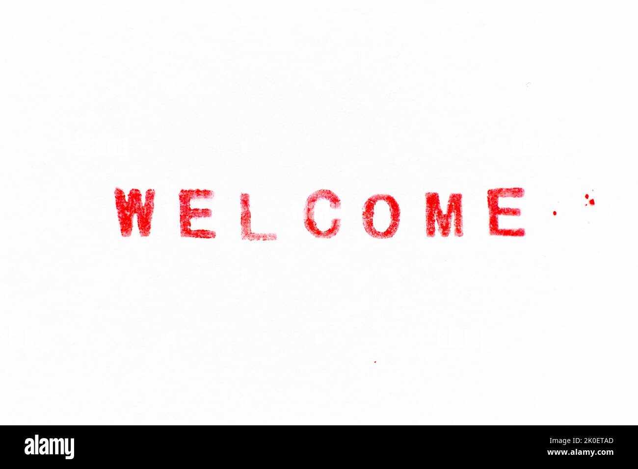 Red color ink rubber stamp in word welcome on white paper background ...