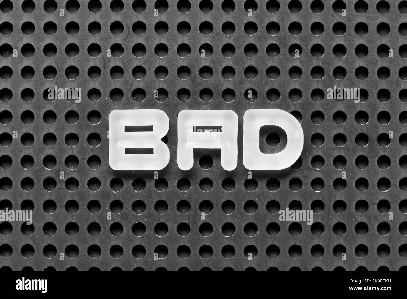White alphabet letter in word bad on black pegboard background Stock ...