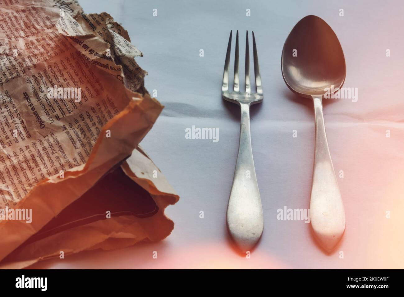 A spoon and a fork on an old newspaper and burnt film light effect ...