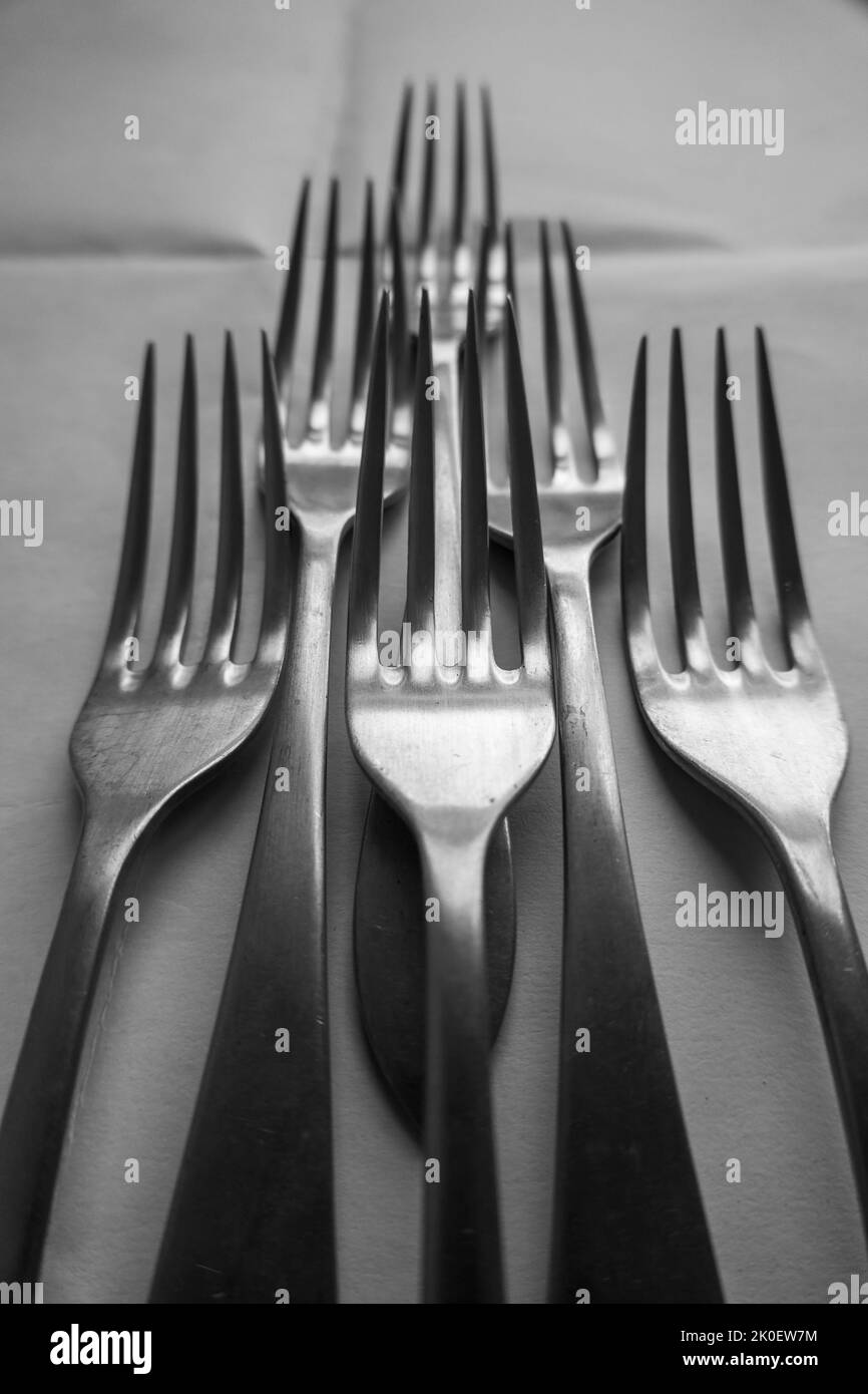 Black and white macro photography with six forks arranged in a pyramid ...