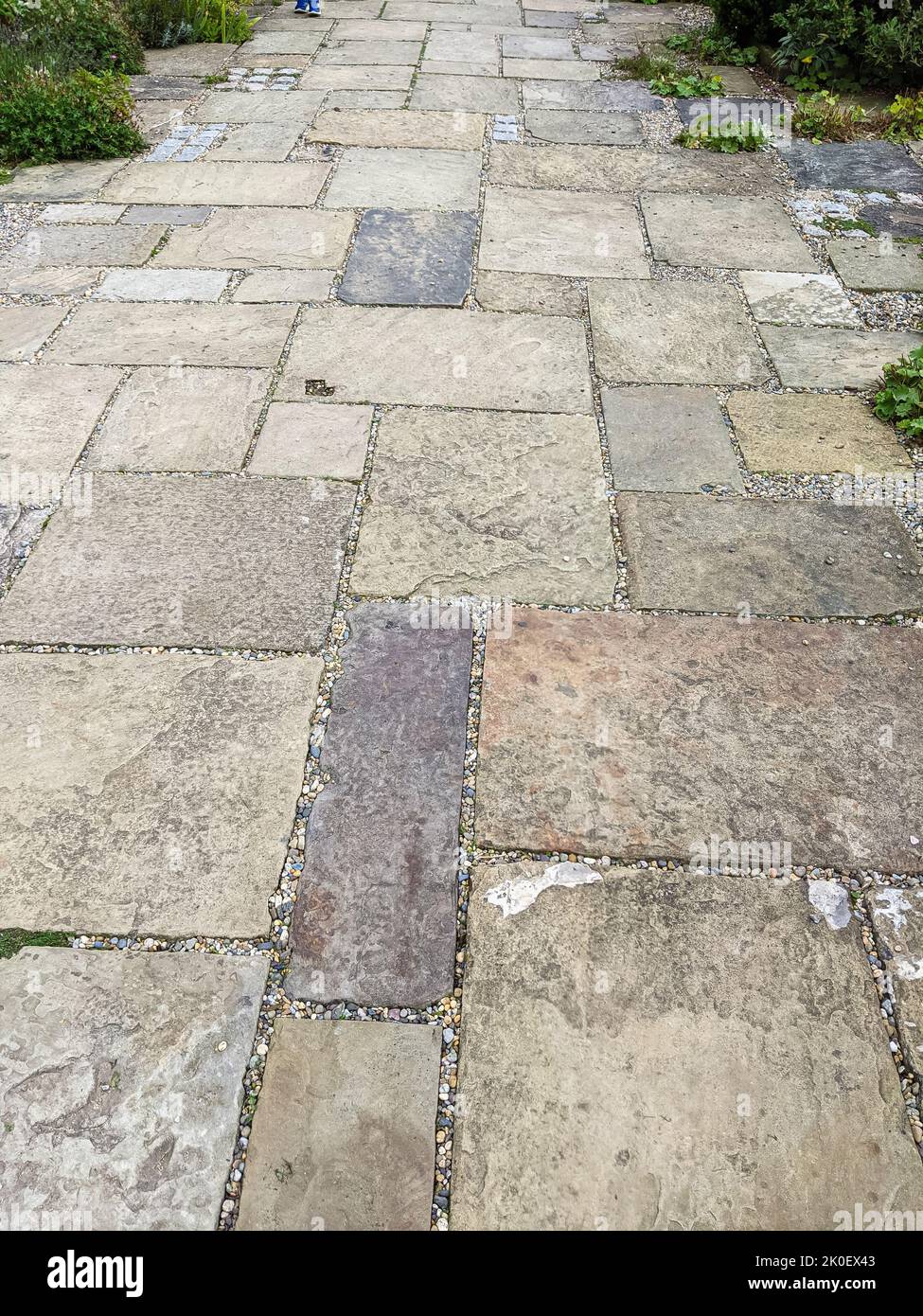 Paving stones of different sizes laid on an old patio Stock Photo - Alamy