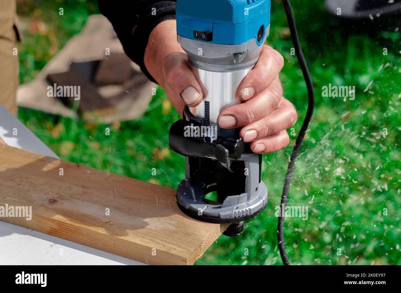 closeup of carpenter with hand wood router machine at work. closeup of ...