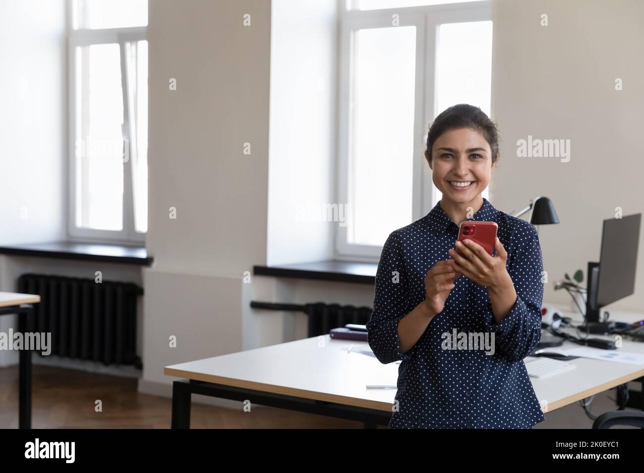 Happy beautiful young Indian business woman holding mobile phone Stock ...
