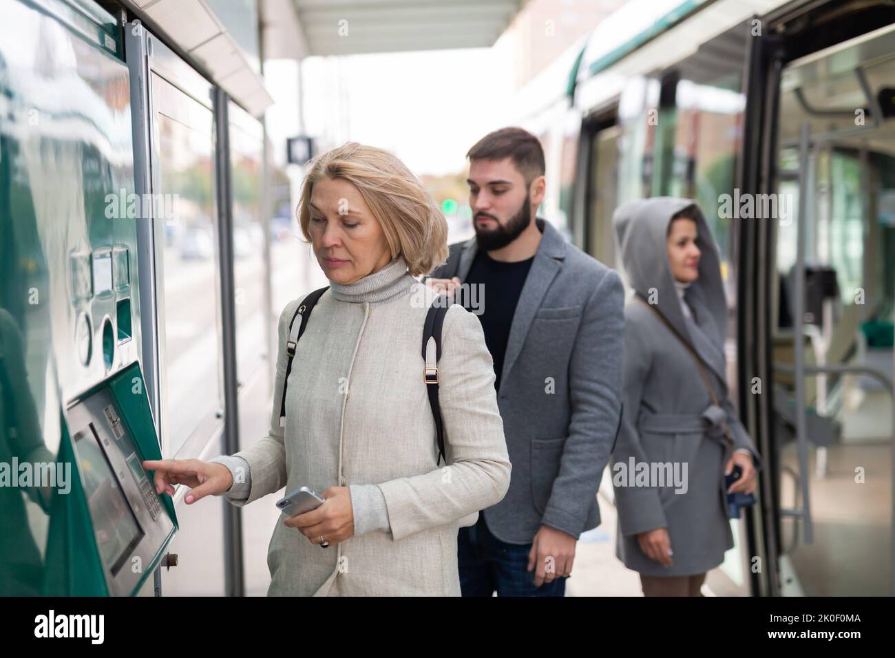 Woman using ticket vending machine Stock Photo - Alamy