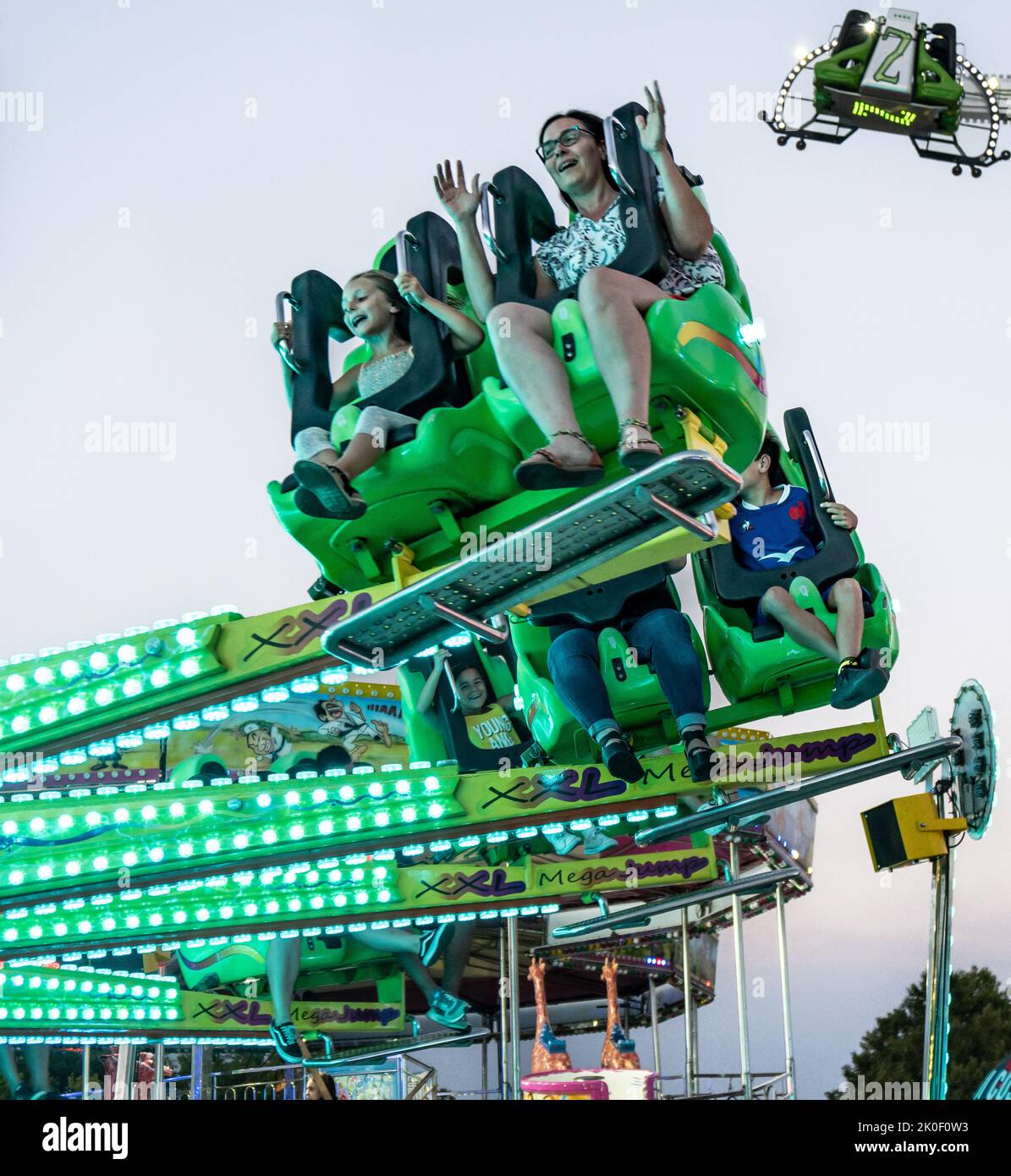 Group of people laughing and enjoying a funfair ride at full speed in ...