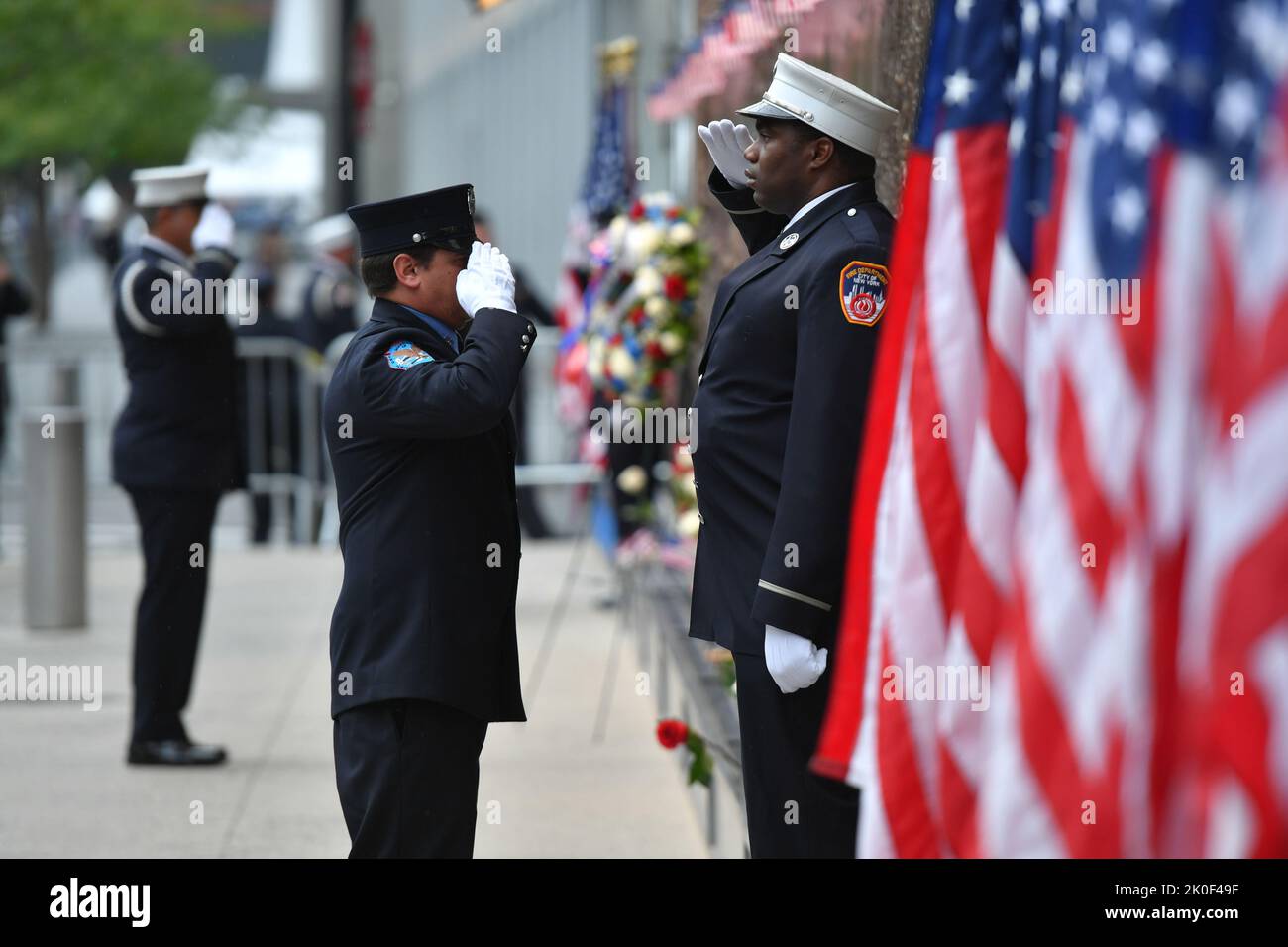 Firefighters salute each other as they stand guard at the FDNY Memorial ...
