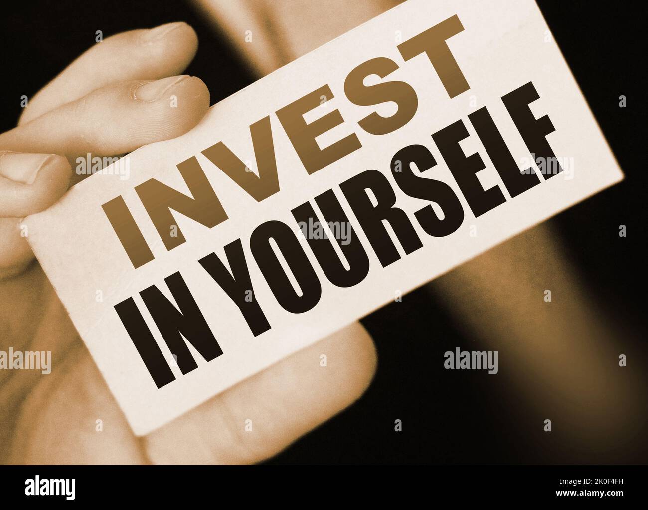 Invest in Yourself message on business card shown by a businessman ...
