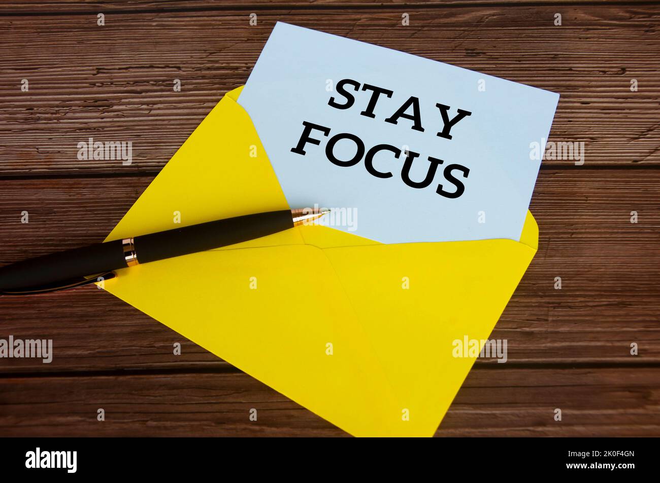 Stay focus text on white notepad with envelope on wooden desk ...