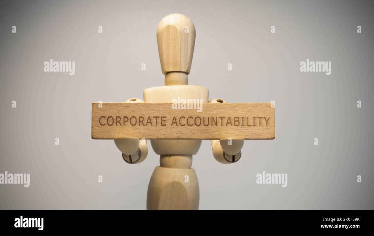 Wooden man holding corporate accountability signboard written on it ...
