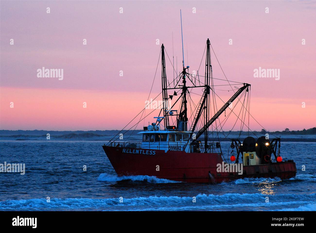 A fishing trawler and ship makes its way through the inlet, on its way ...